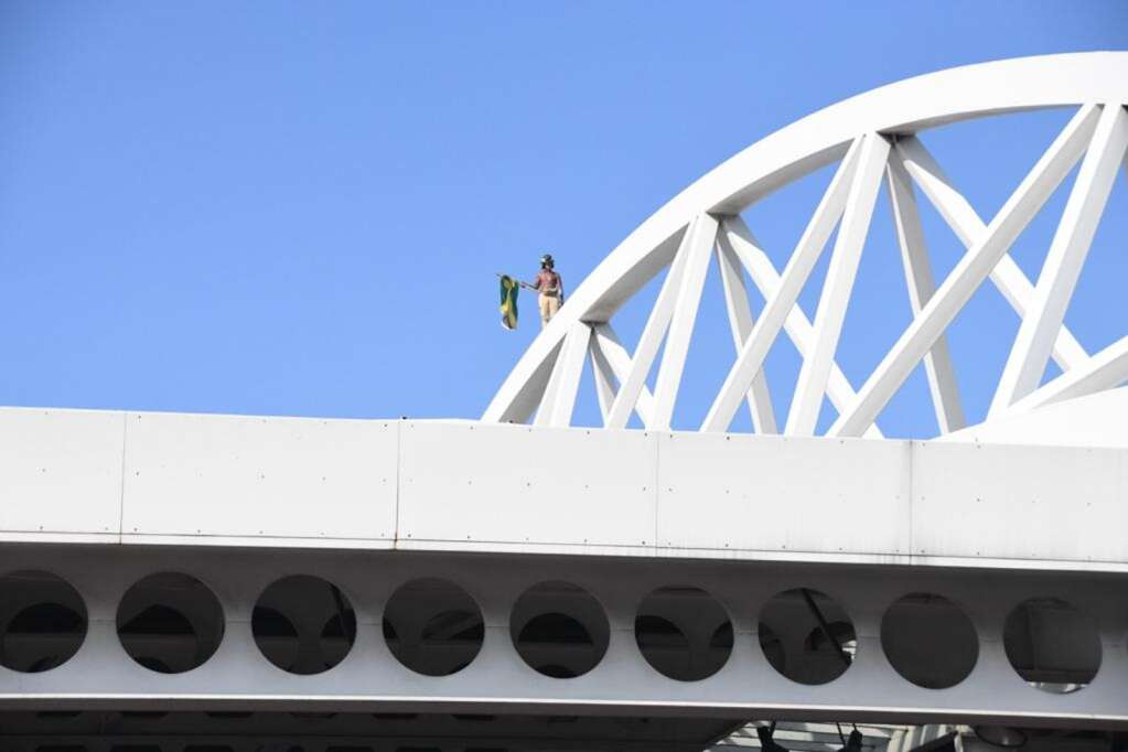 Crowd gathers as man climbs atop Half-Way Tree Transport Centre ...
